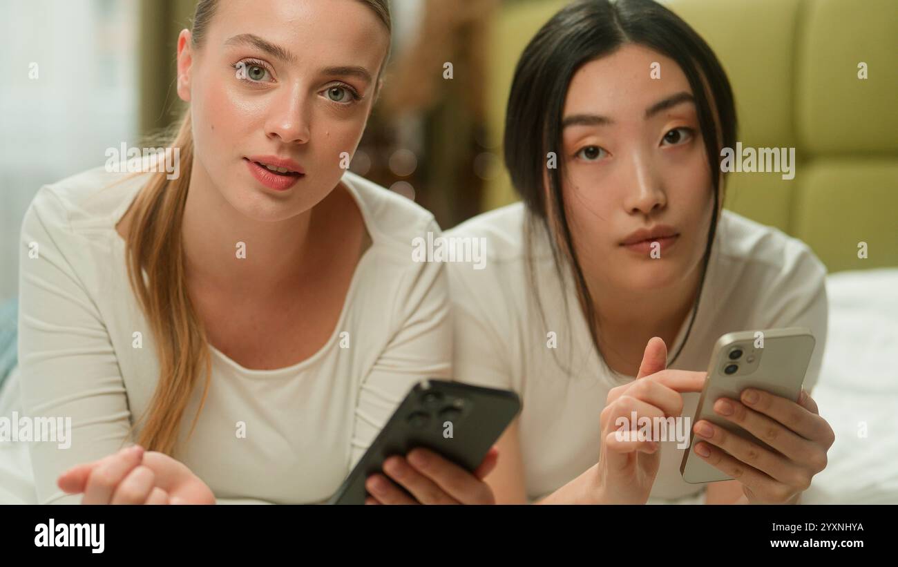 Two happy smiling multiracial friends multiethnic women diversity girls female Caucasian Asian ...