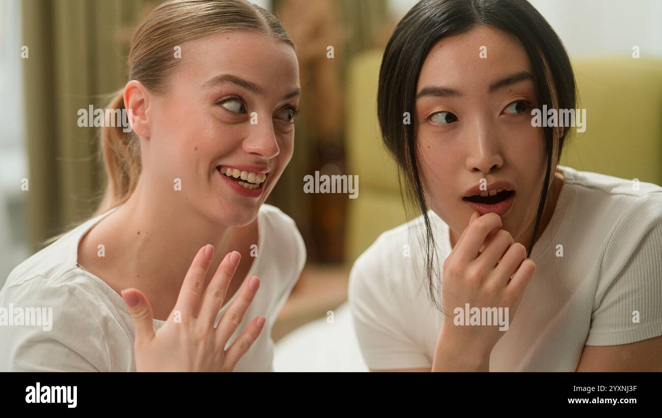 Multiracial friends women Caucasian woman whisper secret gossip talk ...