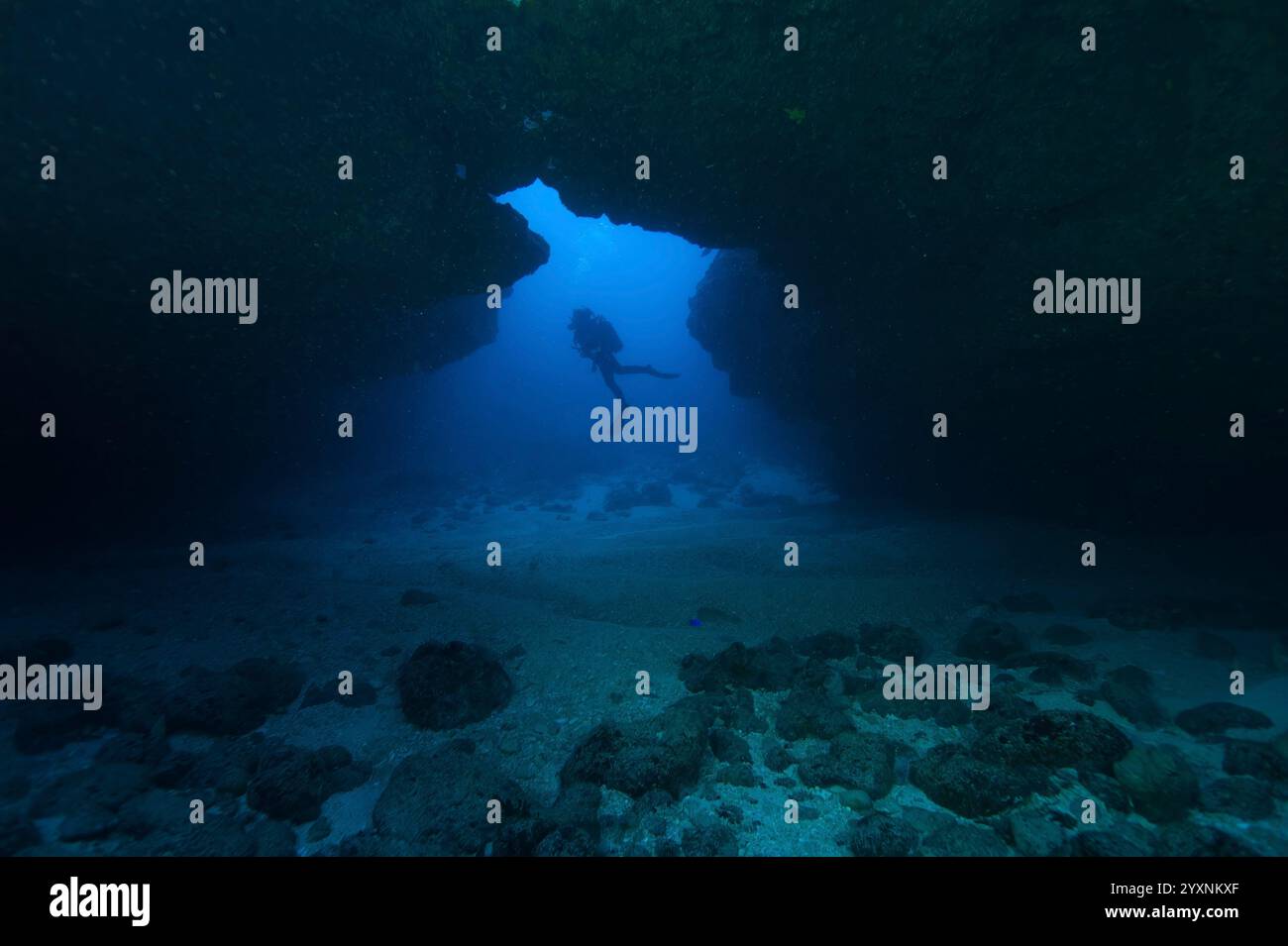 Diver passing through an underwater tunnel in blue water, Flic-en-Flac ...