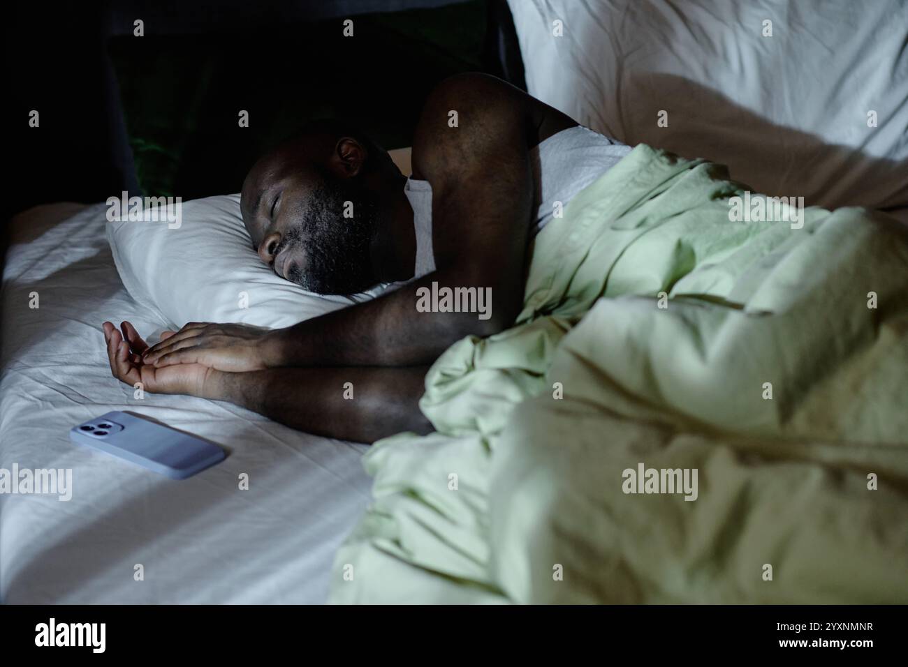 African American man enjoying rest in bed at night, he sleeping in bed ...