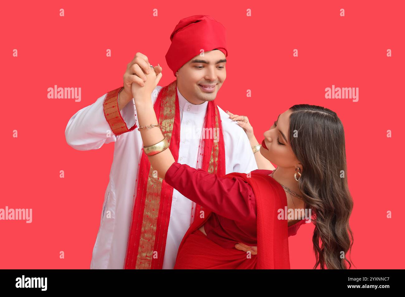 Beautiful Indian couple dancing on red background Stock Photo - Alamy