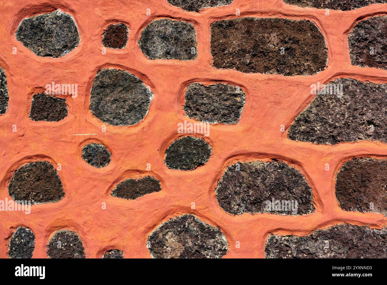 A wall with a pattern of rocks and a red substance. The red substance ...