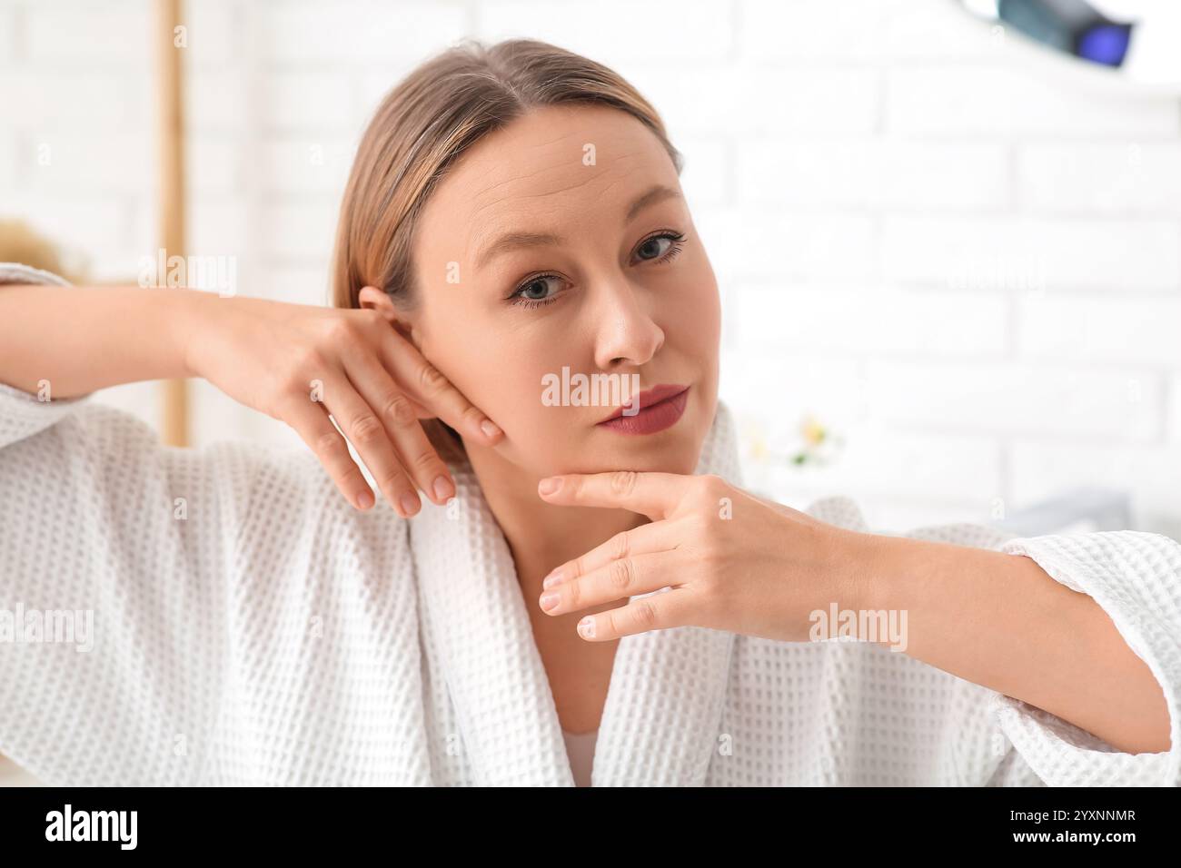 Woman doing face building exercise in bathroom Stock Photo - Alamy