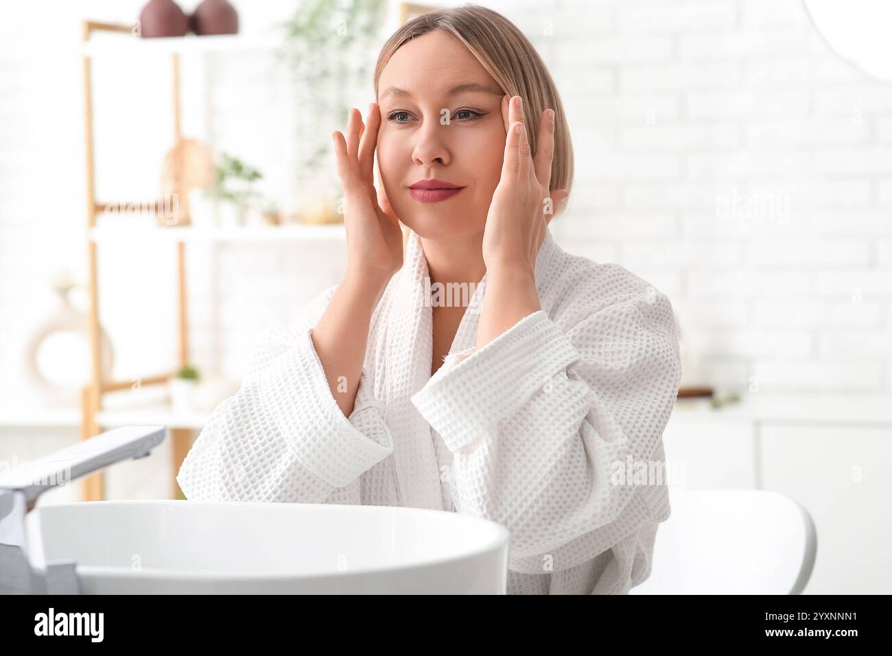 Woman doing face building exercise in bathroom Stock Photo - Alamy