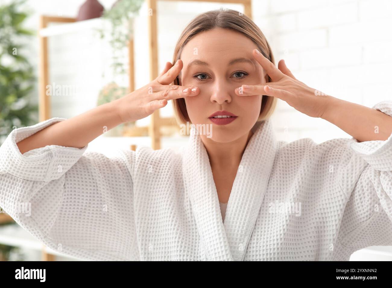 Woman doing face building exercise in bathroom Stock Photo - Alamy