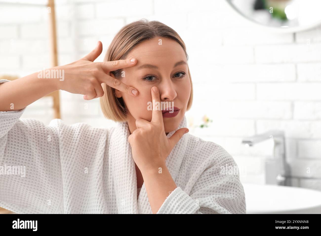 Woman doing face building exercise in bathroom Stock Photo - Alamy