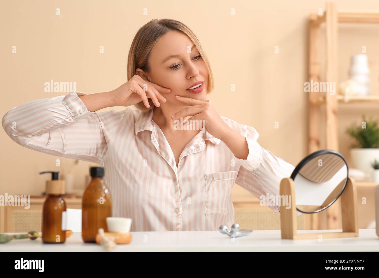 Woman doing face building exercise in bathroom Stock Photo - Alamy