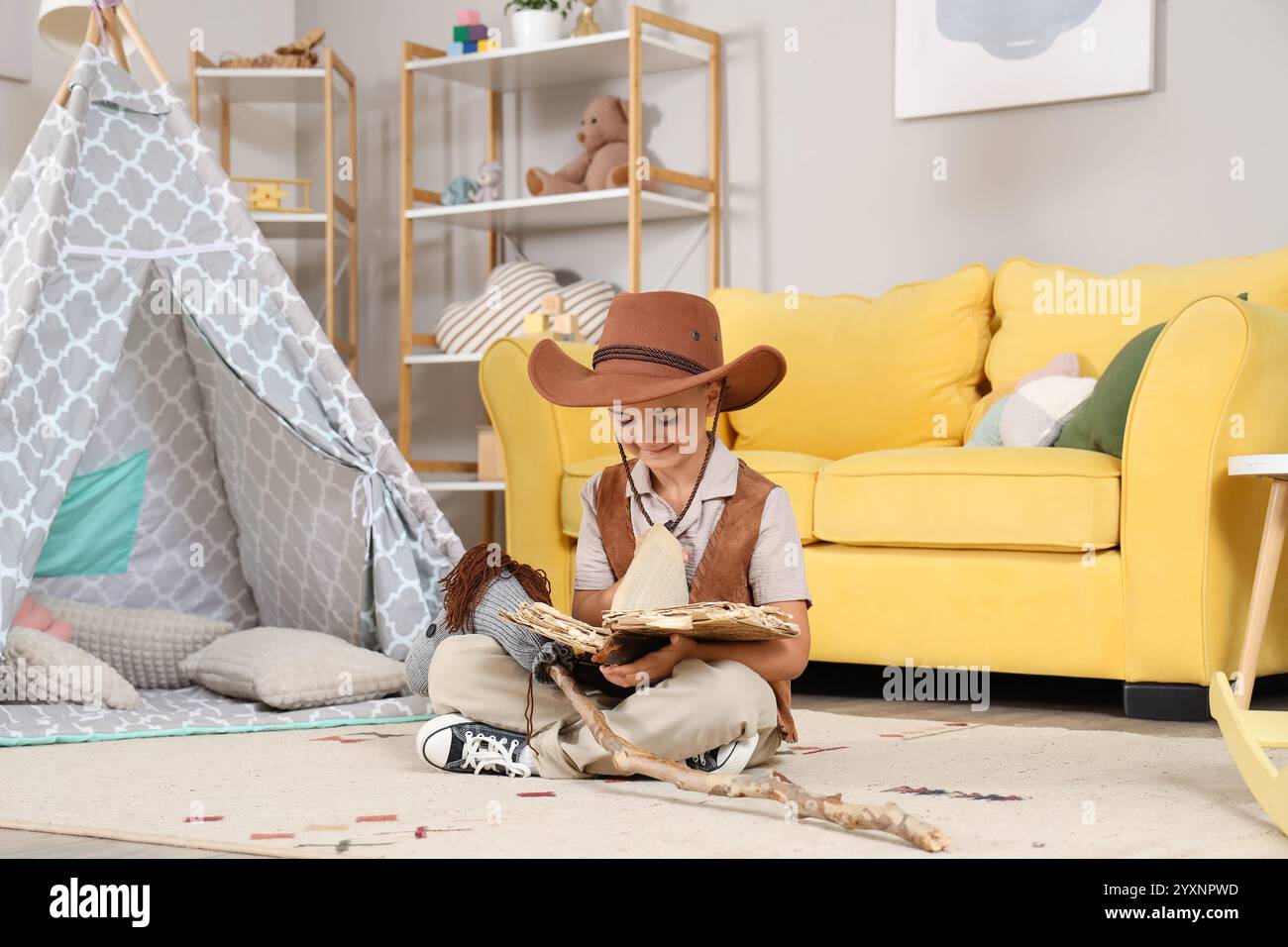 Cute little cowboy reading book at home Stock Photo - Alamy
