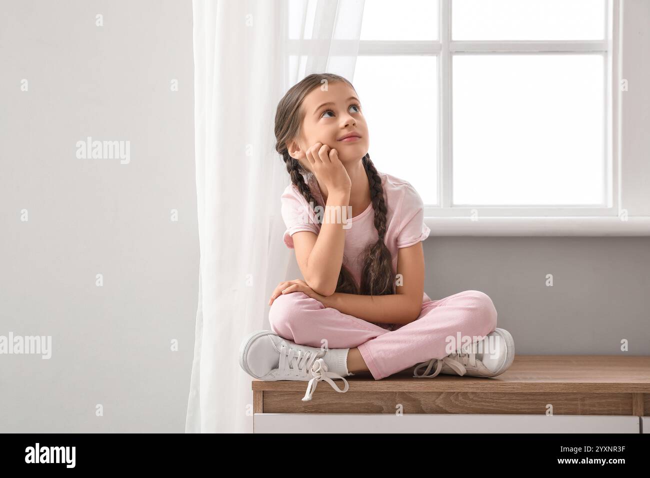 Thoughtful little girl sitting on commode at home Stock Photo - Alamy