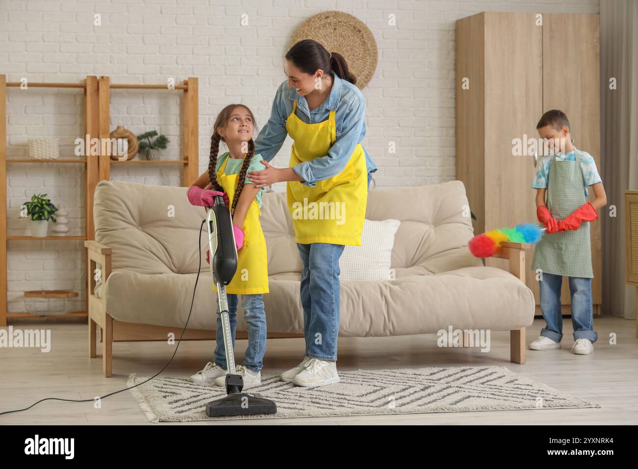 Cute little children helping their mother with cleaning routine at home ...