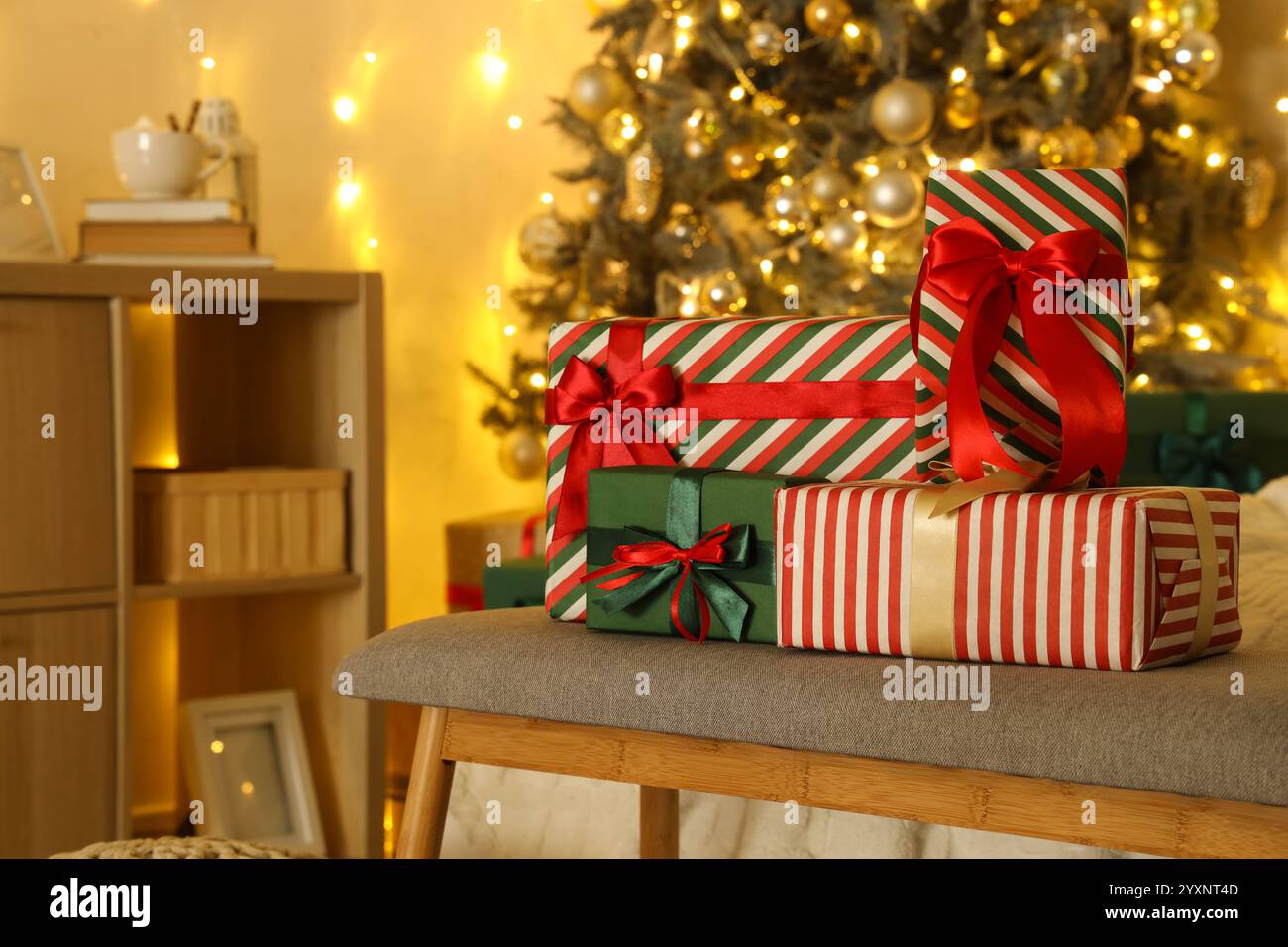 Different gift boxes on bench and beautiful Christmas tree in bedroom ...
