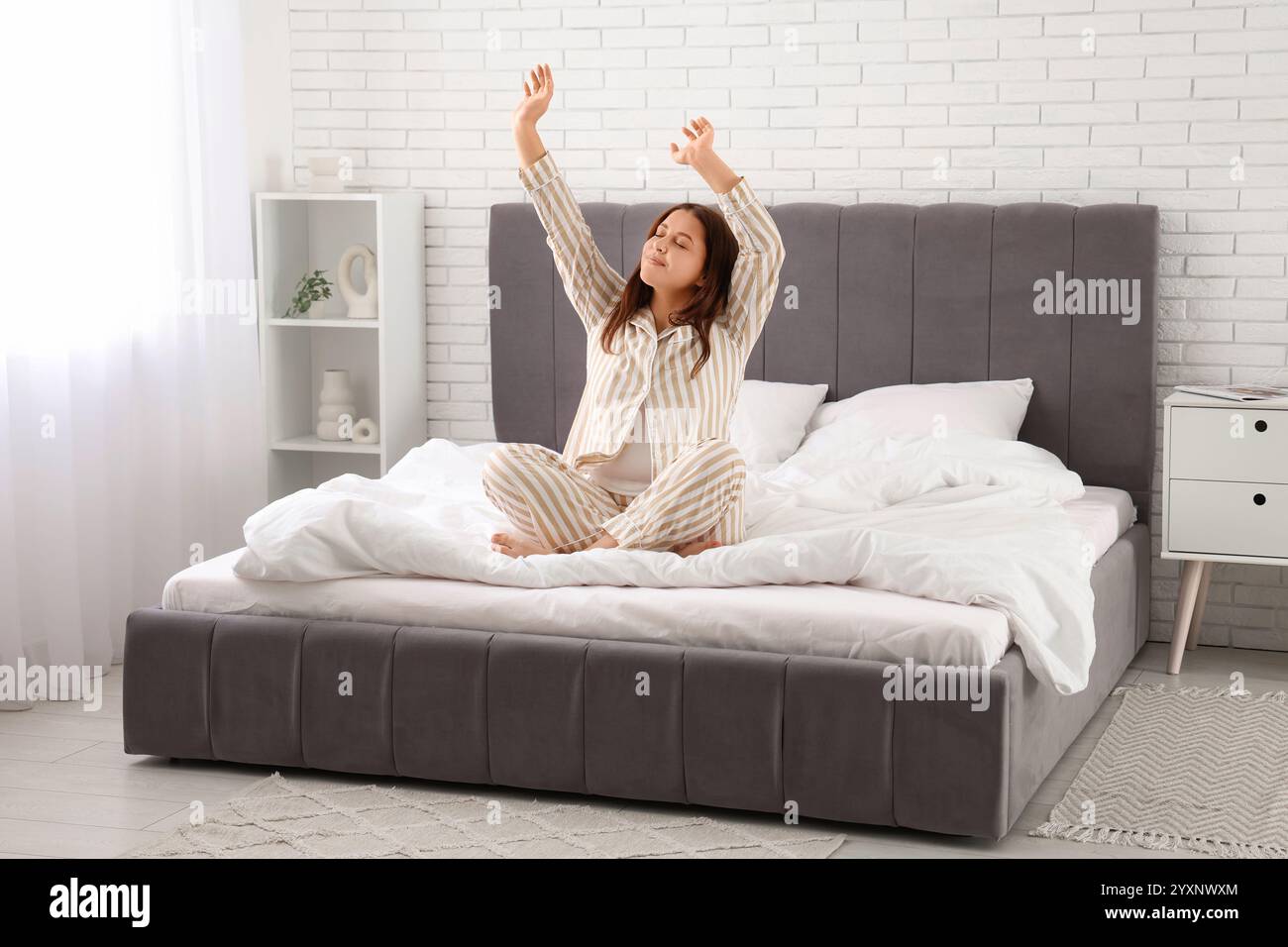 Beautiful young woman stretching in bed at morning Stock Photo - Alamy