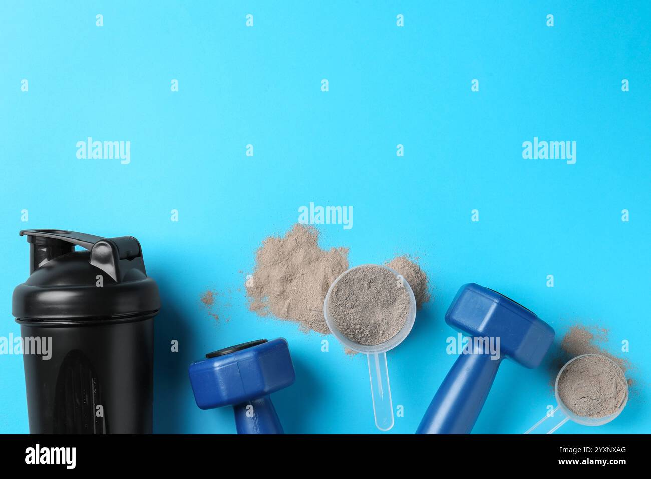 Protein powder, shaker and dumbbells on light blue background, flat lay ...
