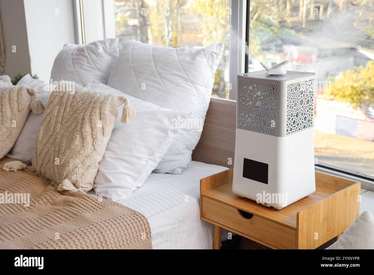 Modern air humidifier on table in bedroom Stock Photo - Alamy