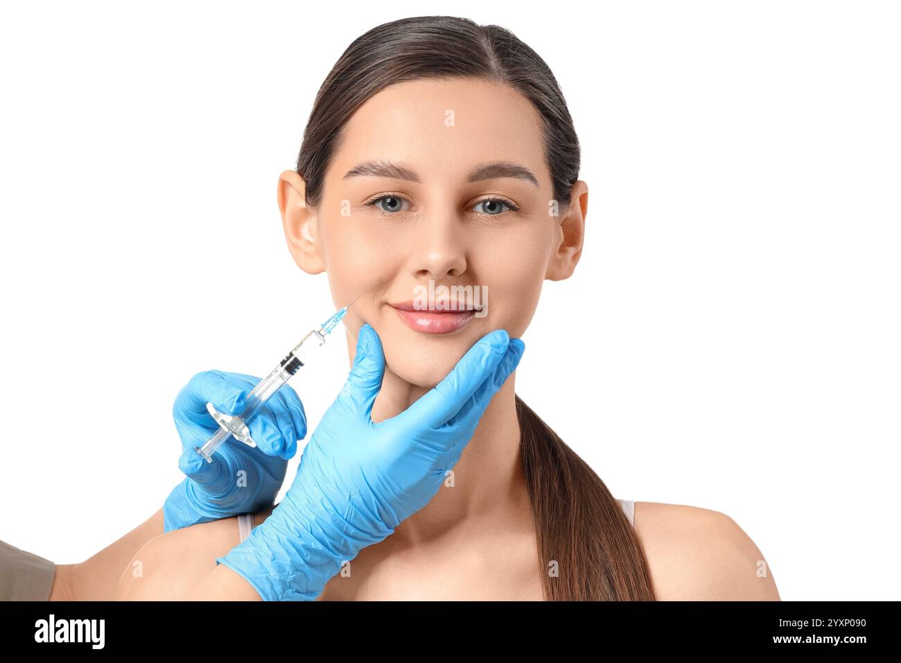 Young girl receiving filler injection in face against white background ...