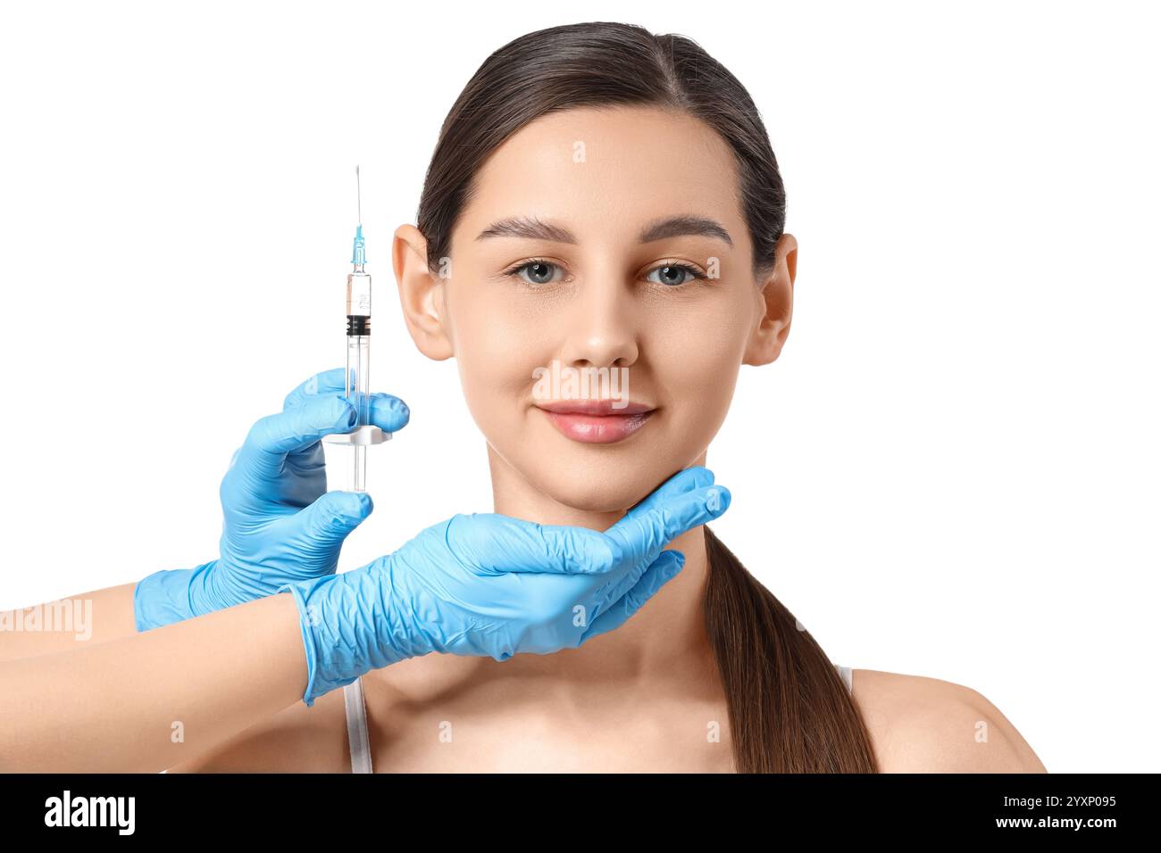 Young girl receiving filler injection in face against white background ...