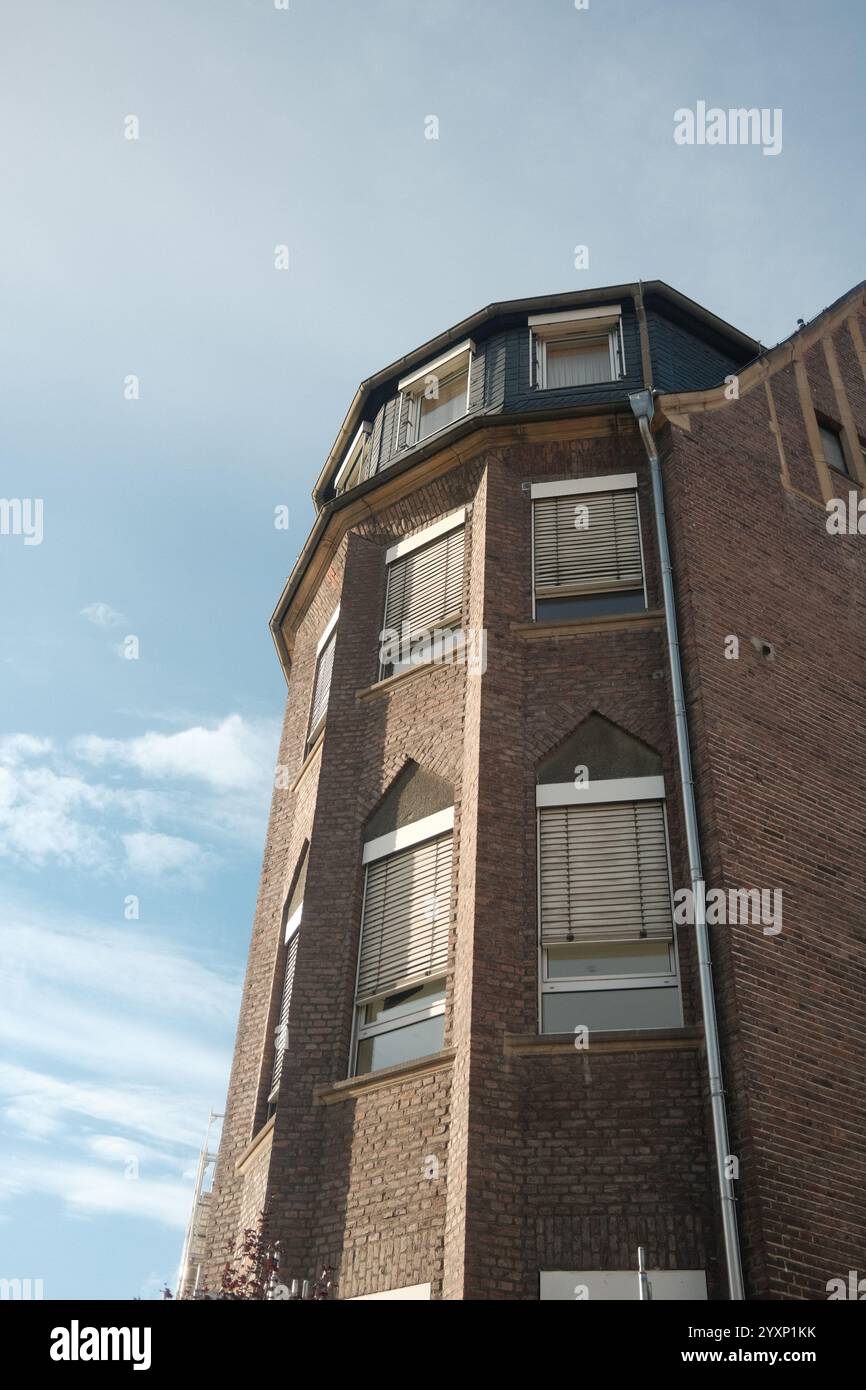 A brick building with a lot of windows and a slanted roof. The building ...