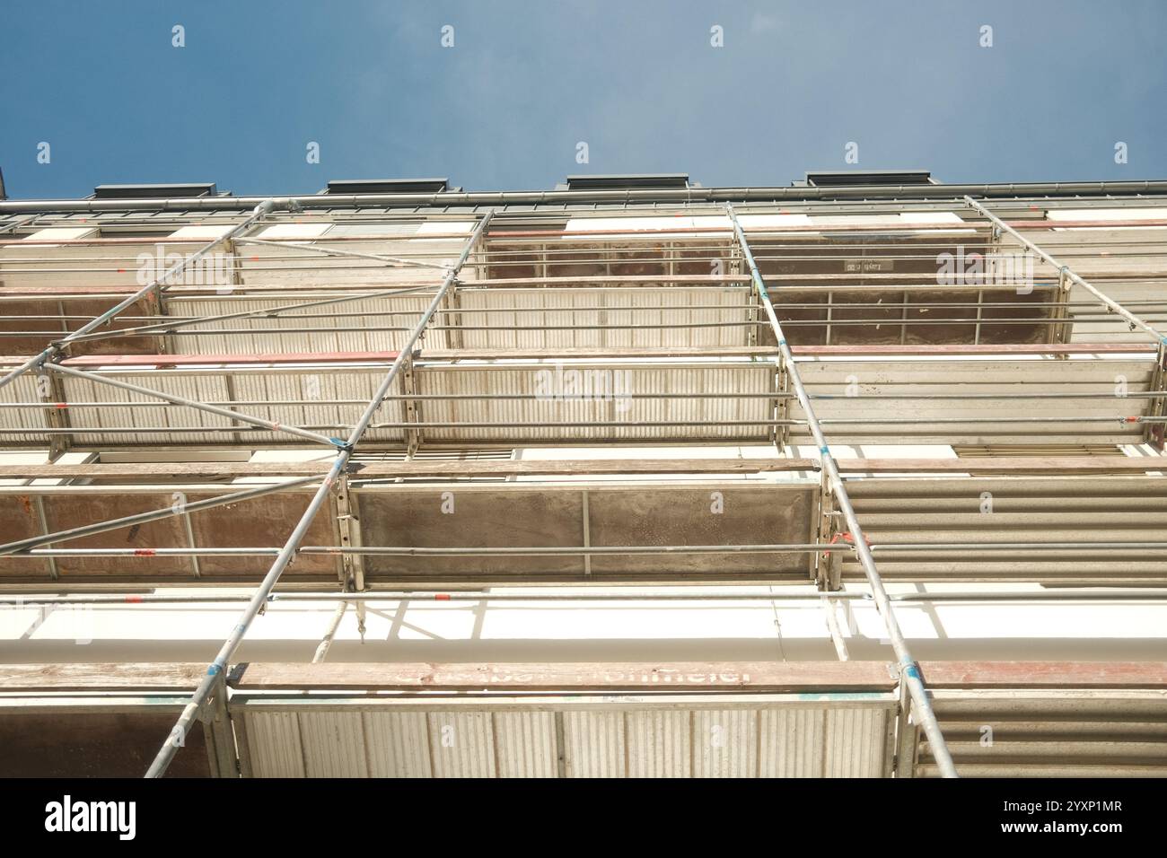A building with scaffolding on it. The scaffolding is blue and red. The ...