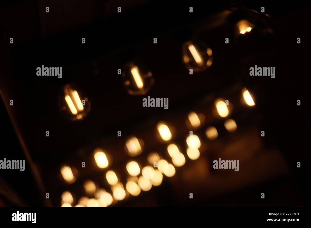 A close up of a dark room with three light switches. The switches are ...