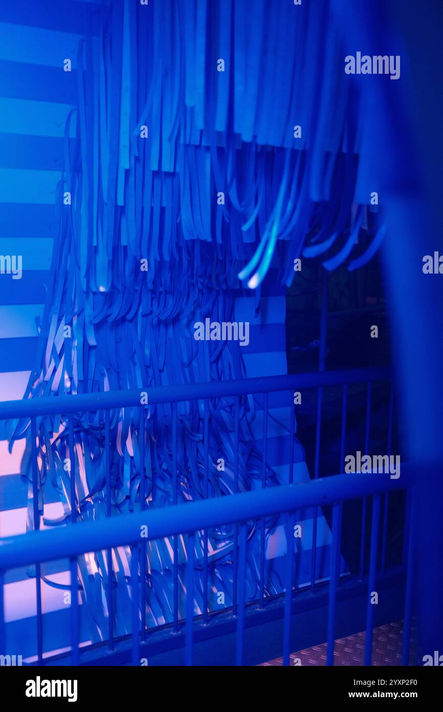 A blue and white striped wall with a blue tarp hanging from it. The ...