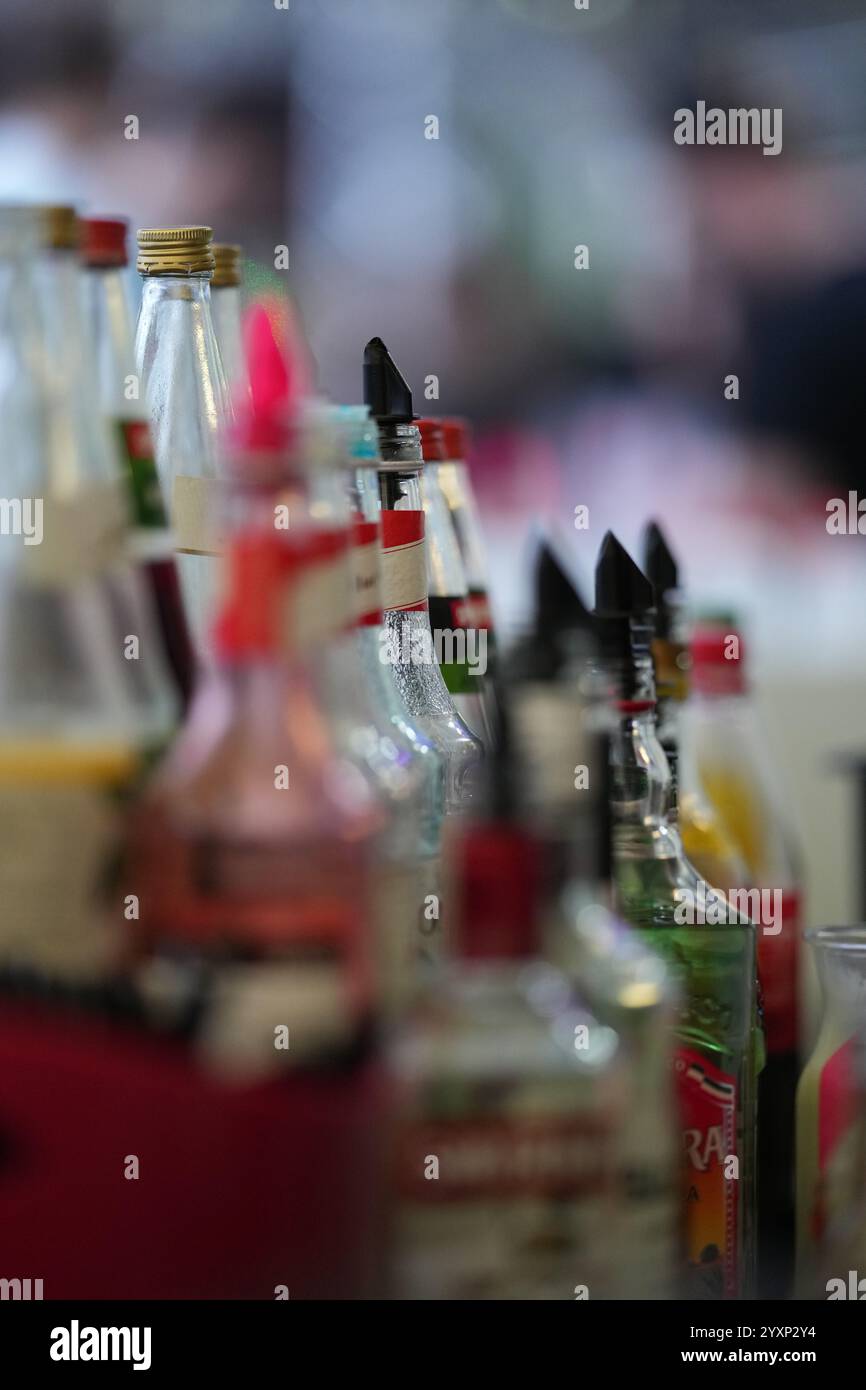 A row of liquor bottles with a red cap on top. The bottles are lined up ...