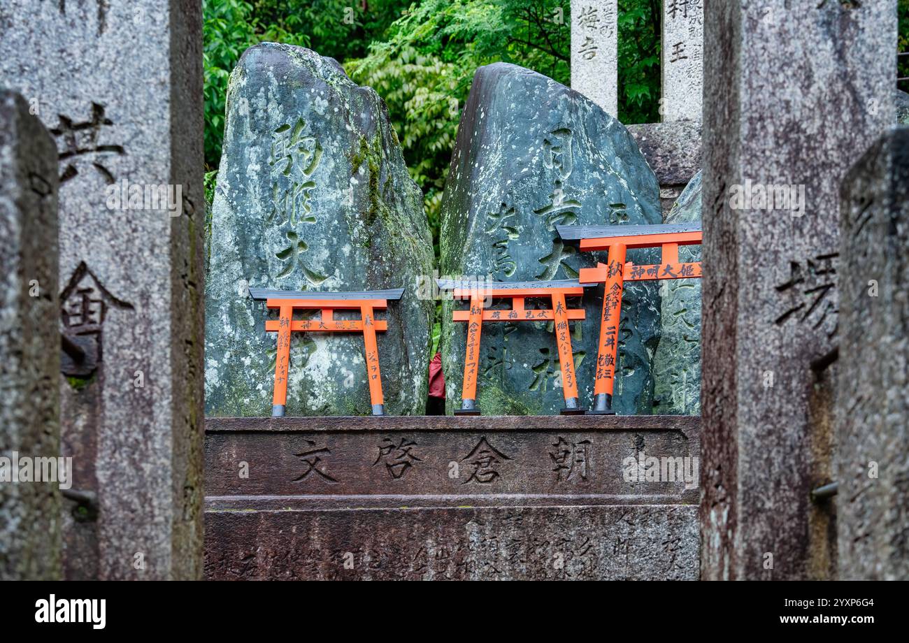 Small shinto place of worship with Torii Gates and inscriptioned stones ...