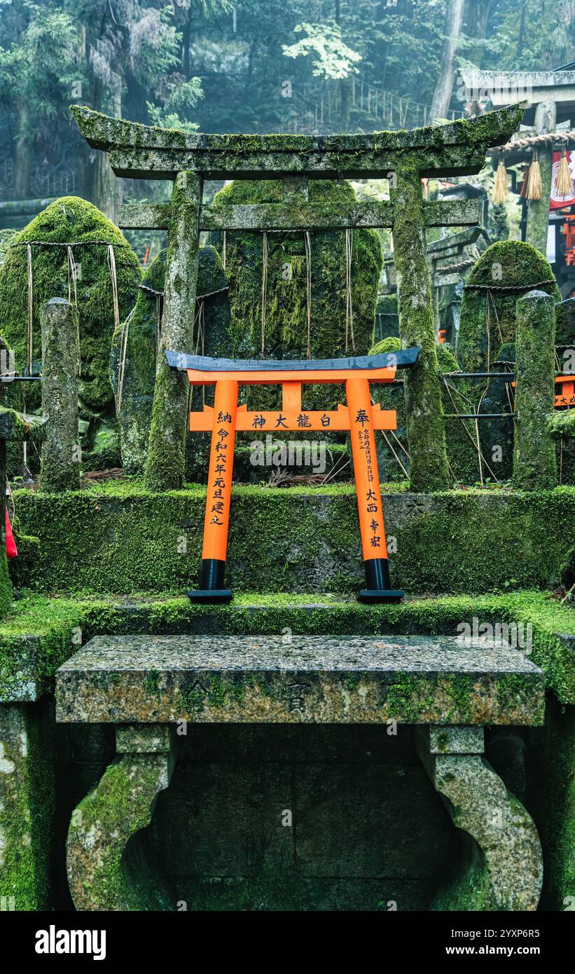 Small shinto place of worship with Torii Gates and inscriptioned stones ...