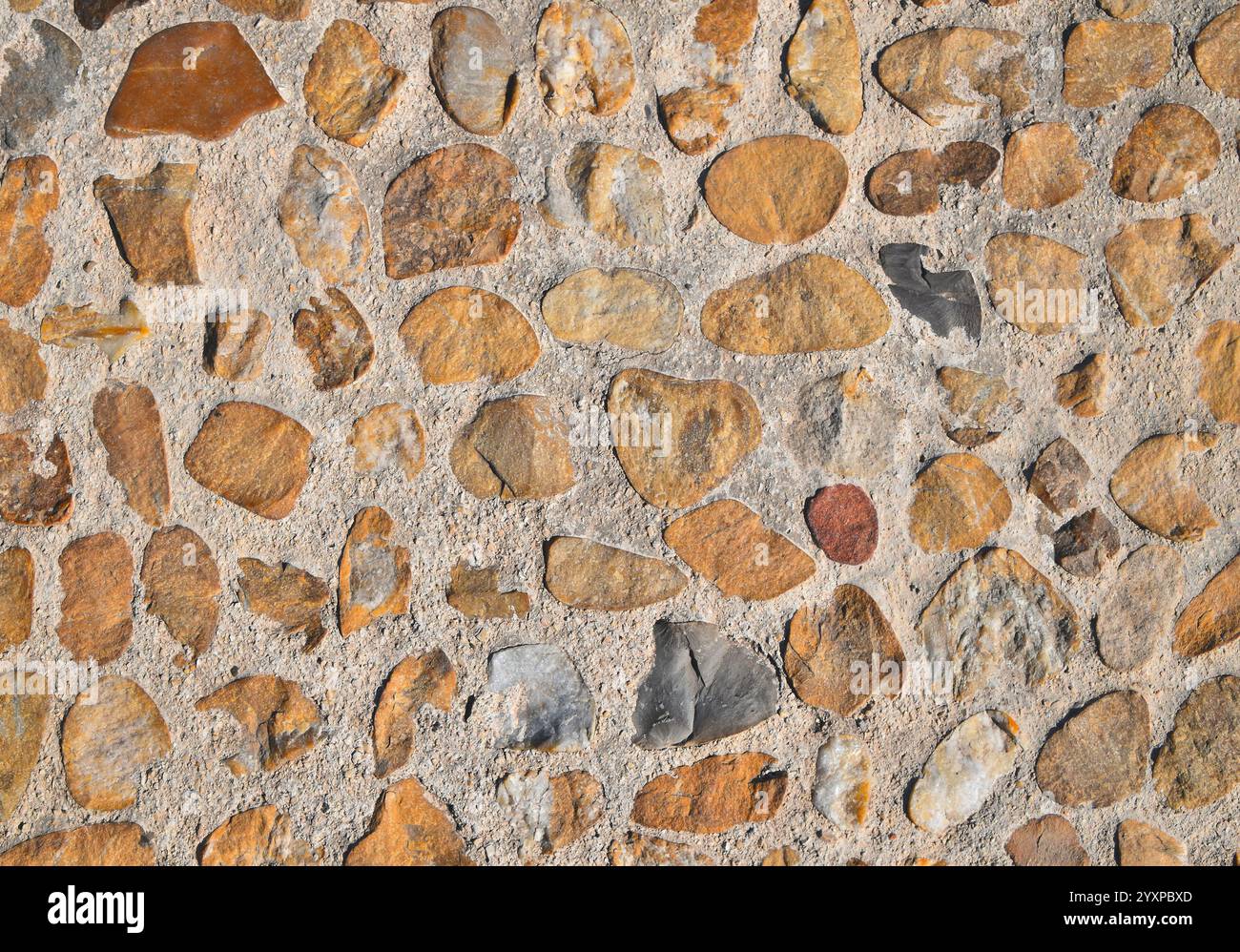 Decorative stone wall made with colorful pebbles of various shapes and ...