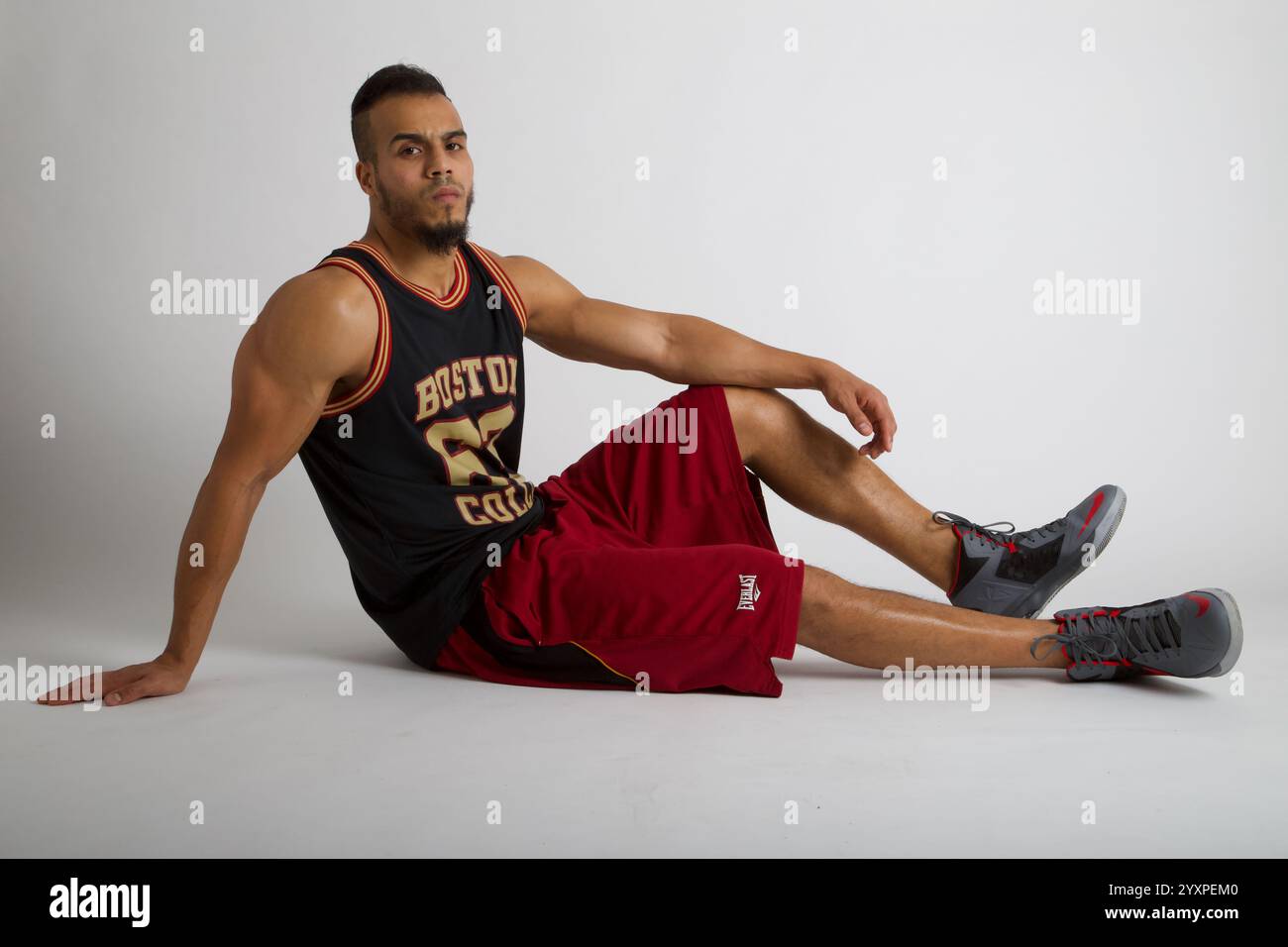 Man sitting in basketball kit Stock Photo - Alamy