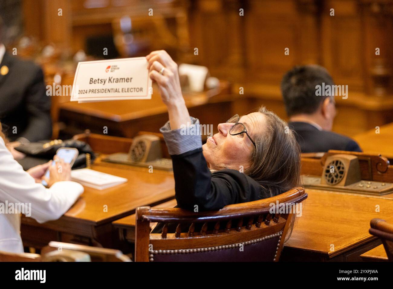 Georgia Republican elector Betsy Kramer shows her name placard to ...