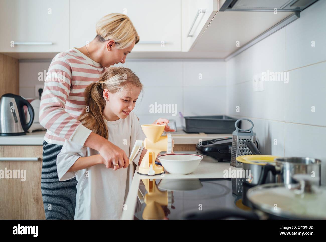 Mother and daughter enjoy cooking session together in modern kitchen ...