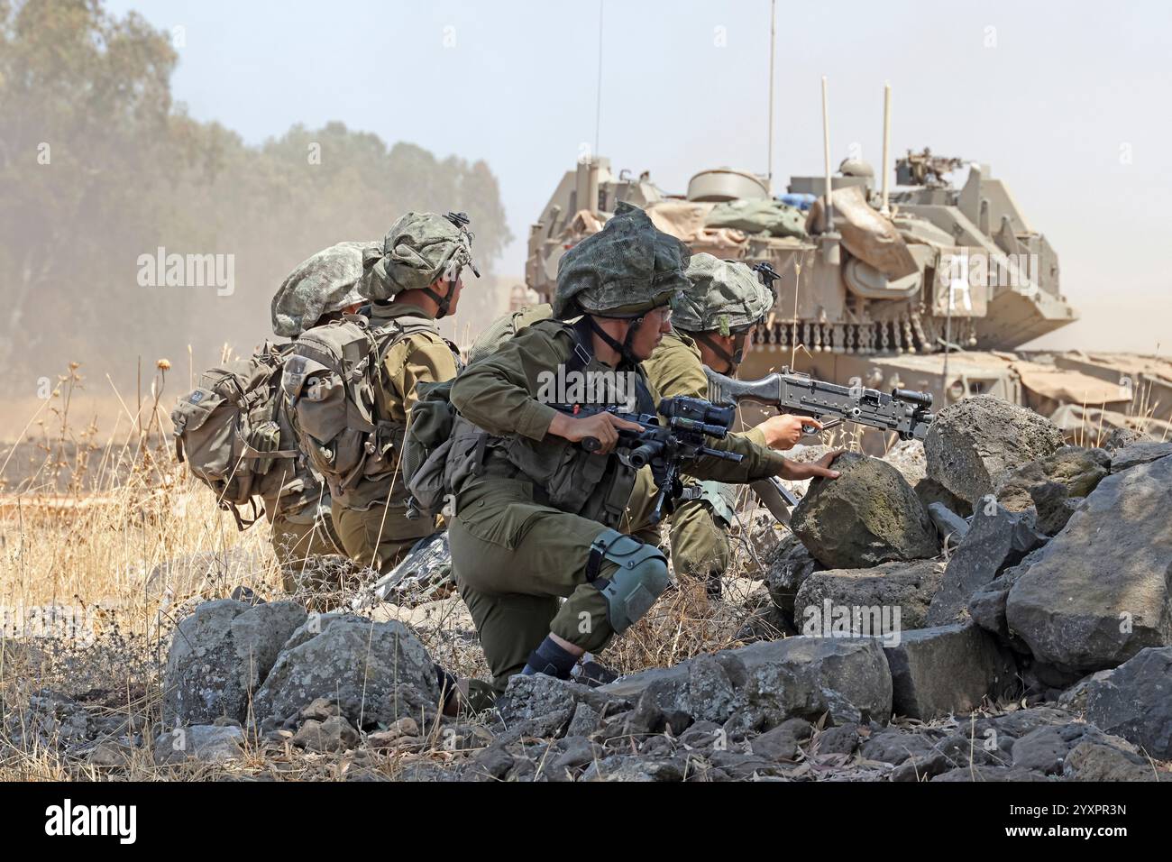 Infantry soldiers take position behind a Merkava battle tank of the ...