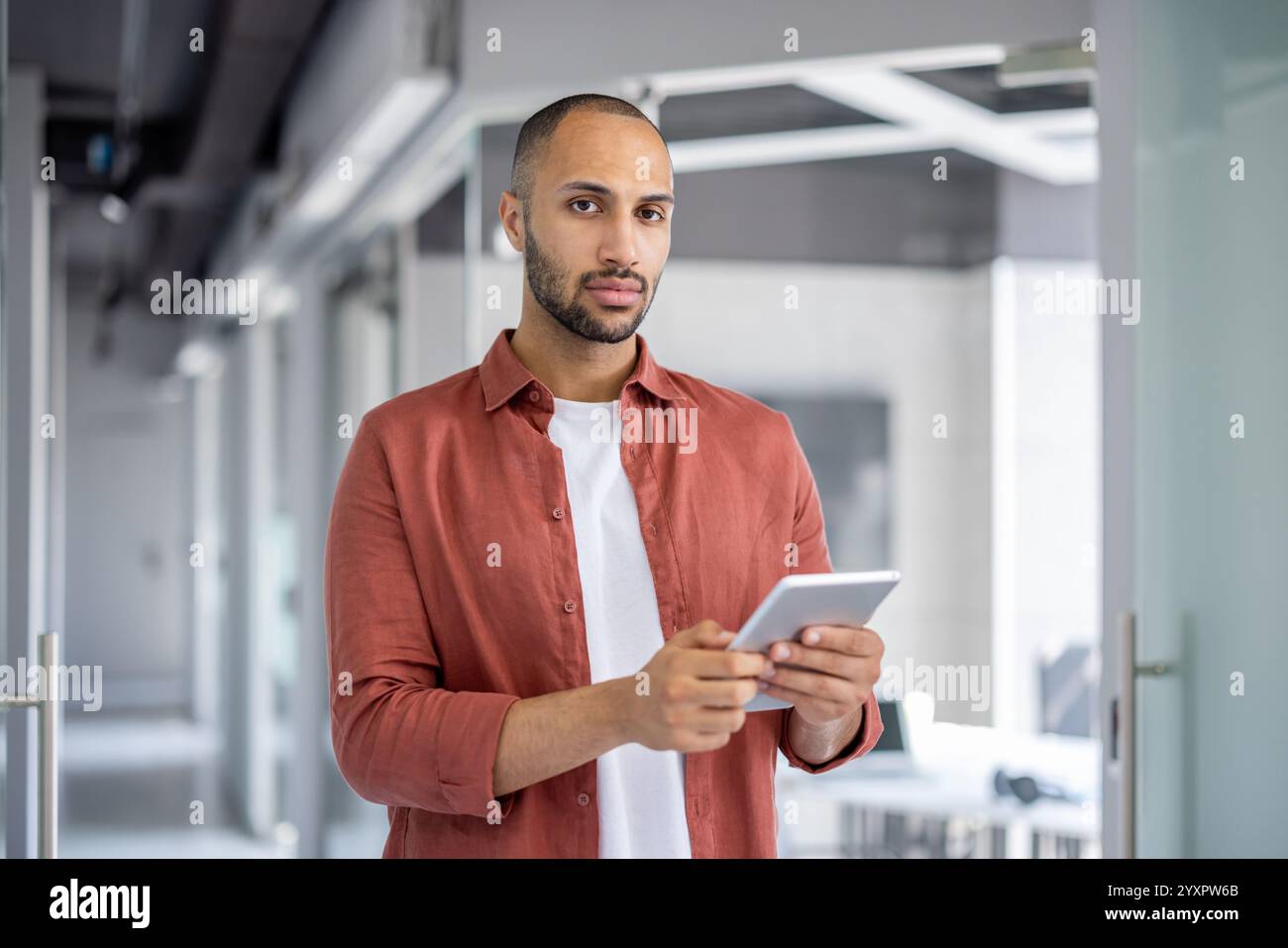 A focused individual in a contemporary office setting. The image ...
