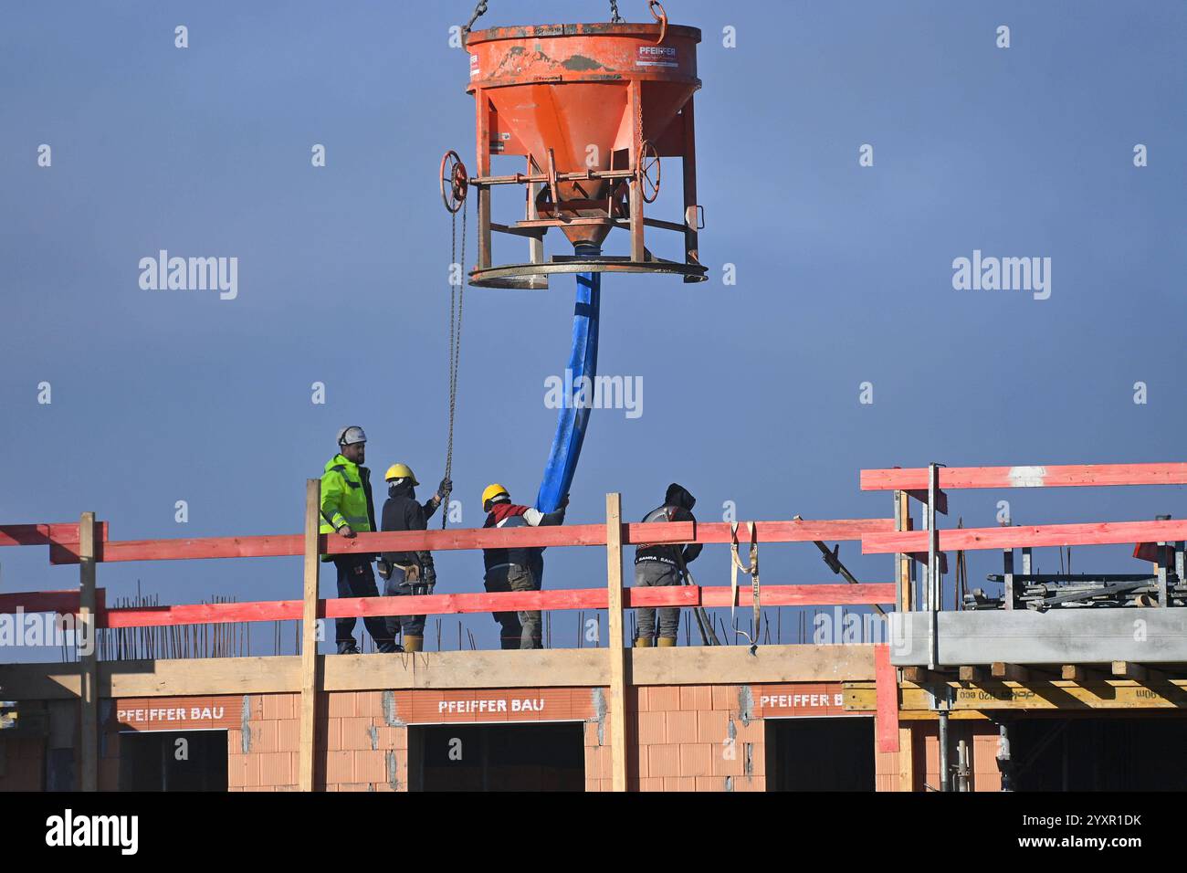 Bauarbeiter auf einer Grossbaustelle in Muenchen giessen Beton ...