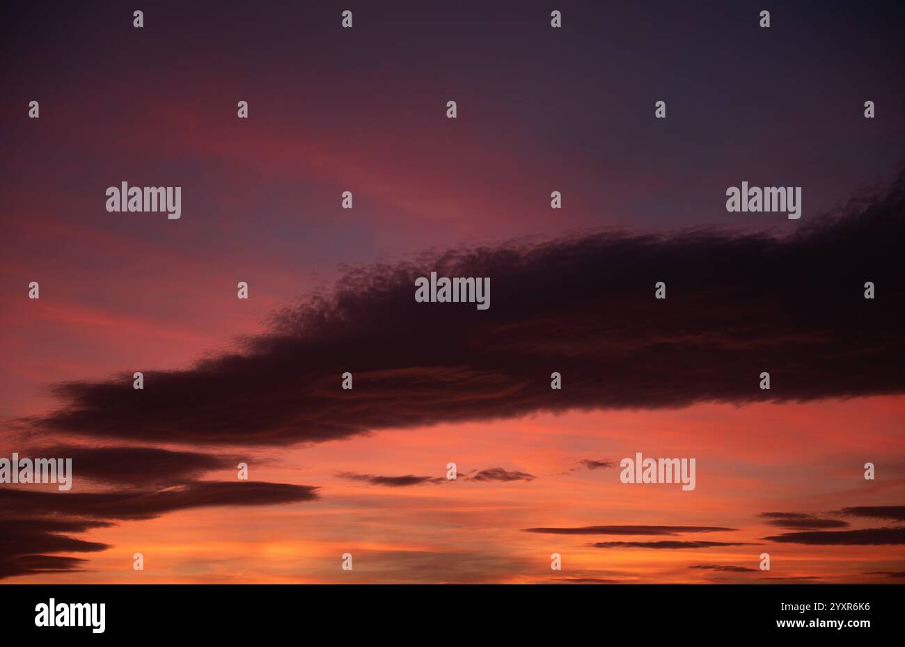 Sunset Sky Aglow with Radiant Clouds.The sunset sky is aglow with radiant clouds painted in hues ...