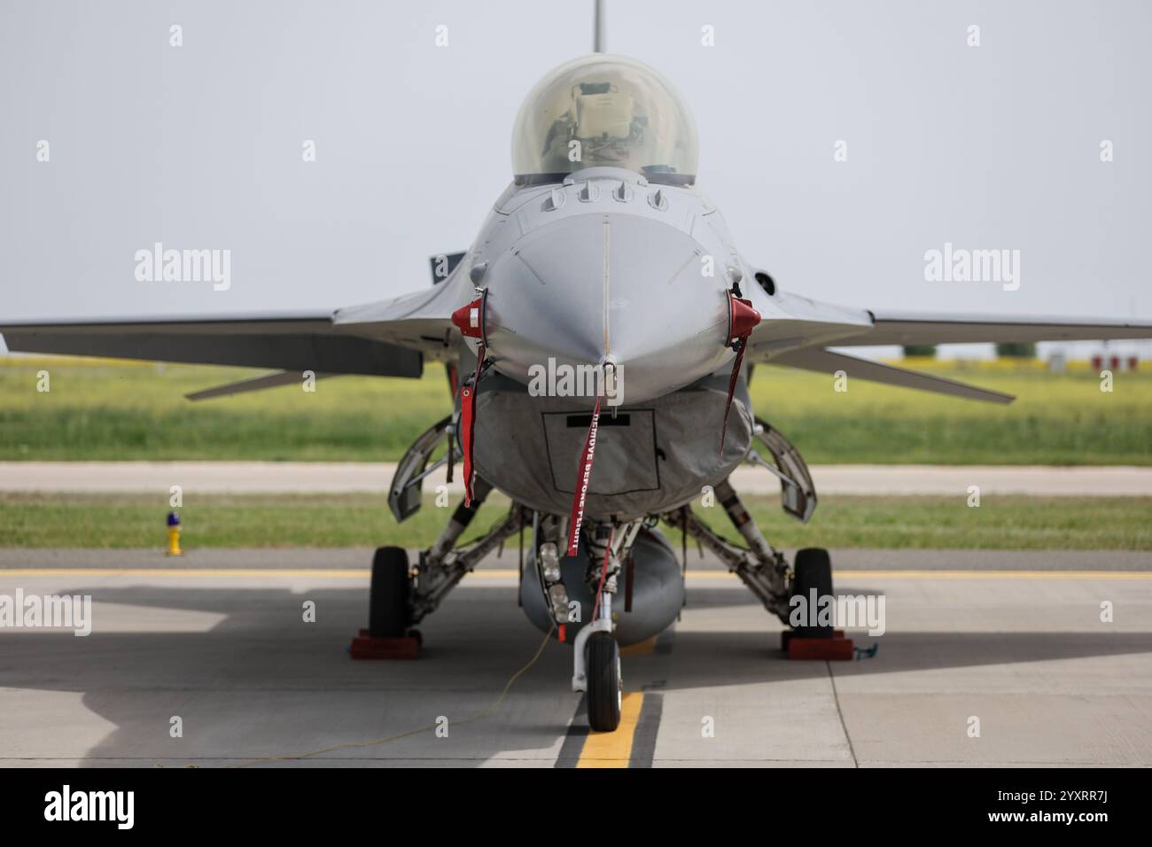 Fighter jet in parking position with red remove before flight ribbon ...