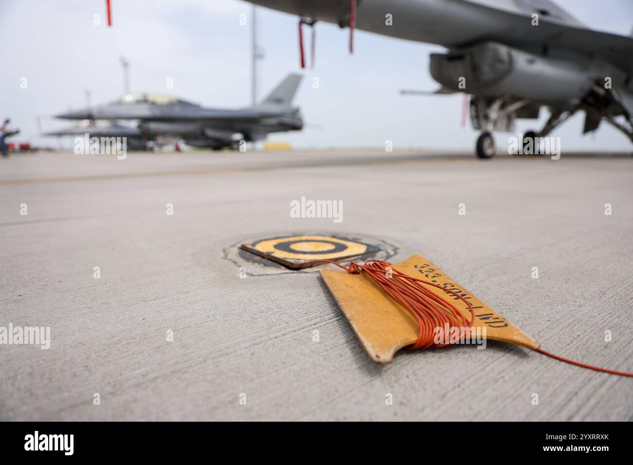 Electrical grounding cables are seen on a runway. Military fighter ...