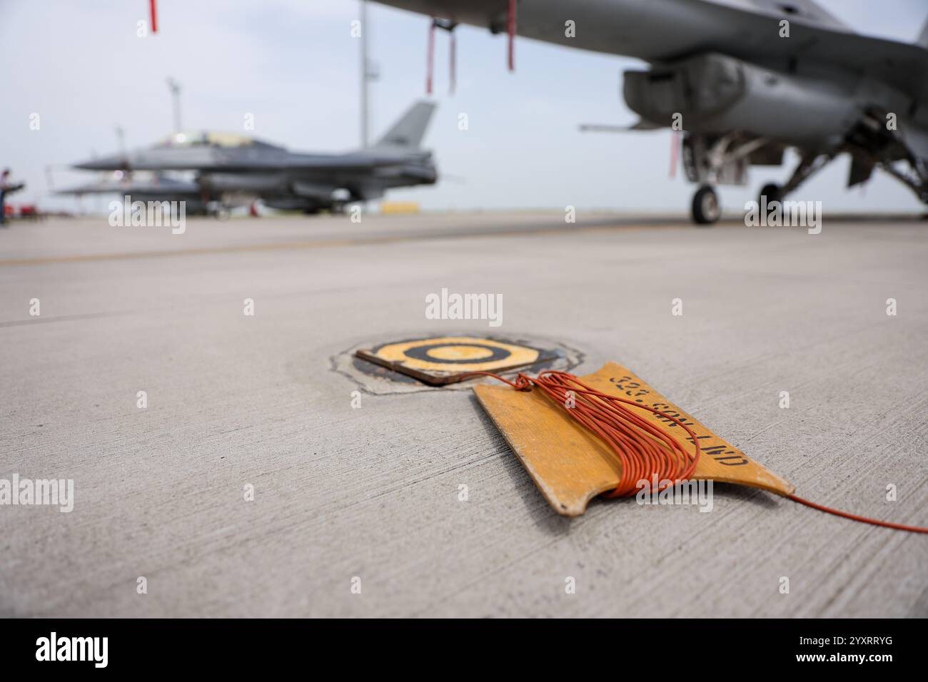 Electrical grounding cables are seen on a runway. Military fighter ...