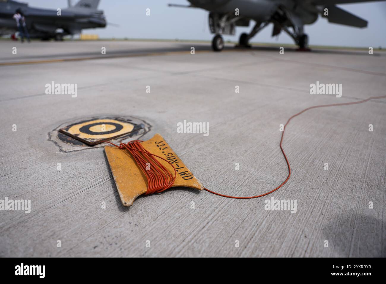 Electrical grounding cables are seen on a runway. Military fighter ...