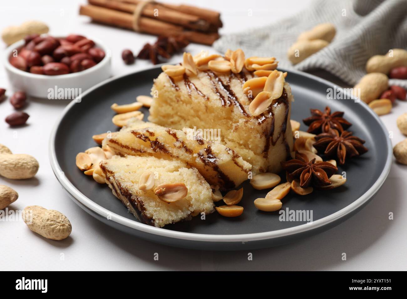 Delicious sweet semolina halva with peanuts and spices on white table ...