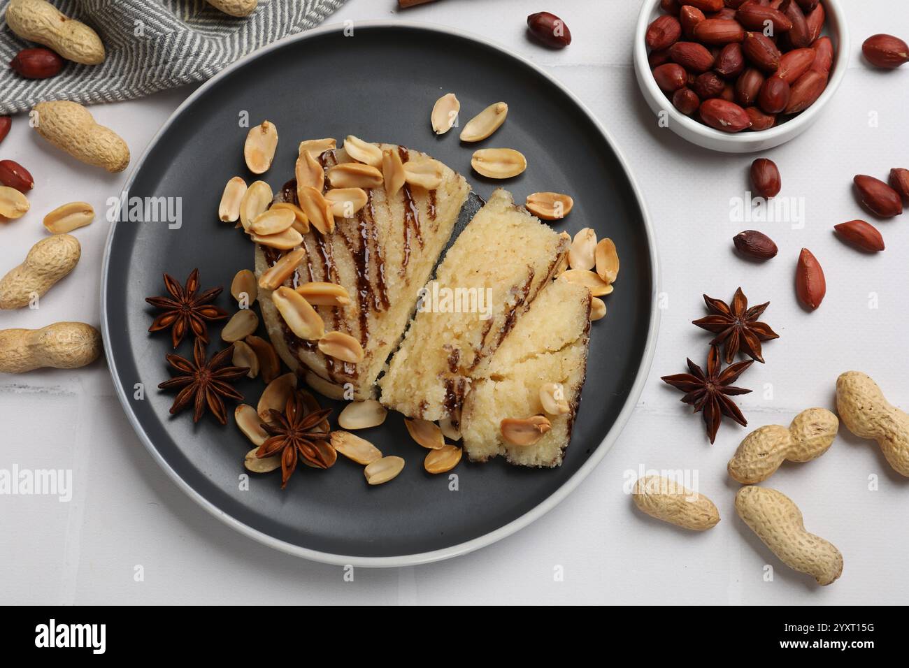 Delicious sweet semolina halva with peanuts and spices on white tiled ...