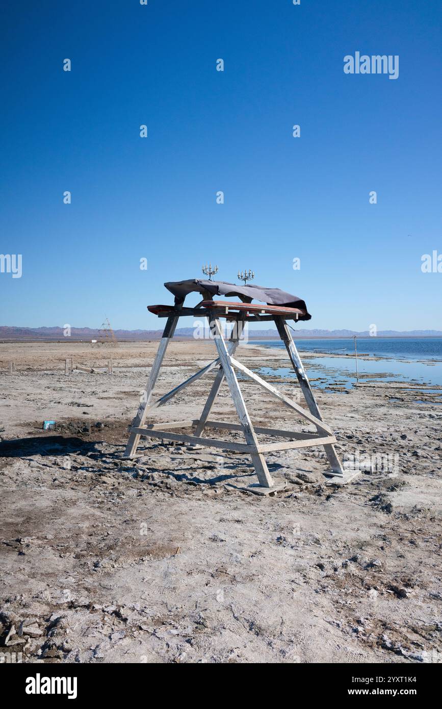 Very tall table with two candlelabra on it on the beach at Bombay Beach ...