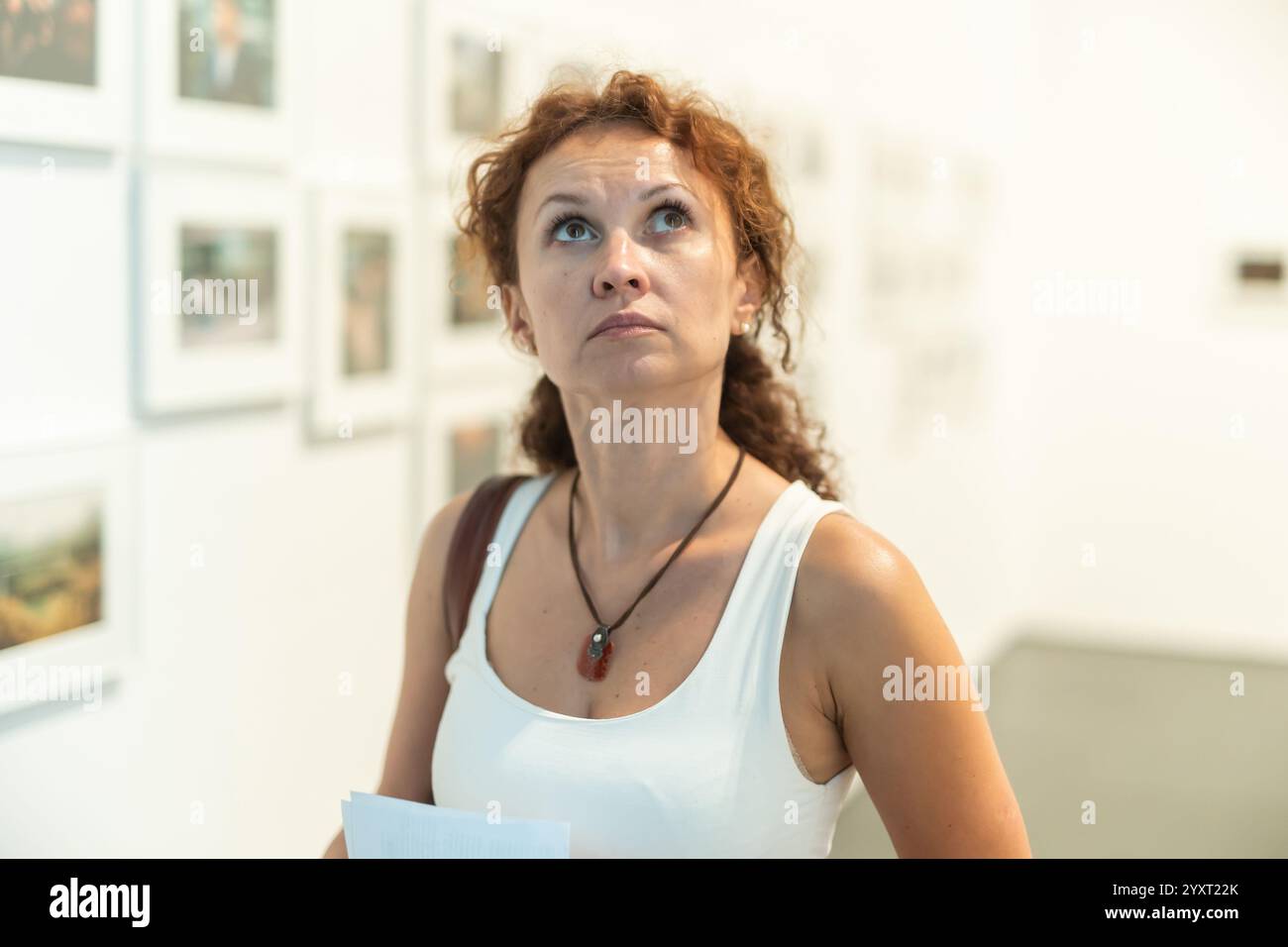 Woman observing photographs on display in photo gallery Stock Photo - Alamy