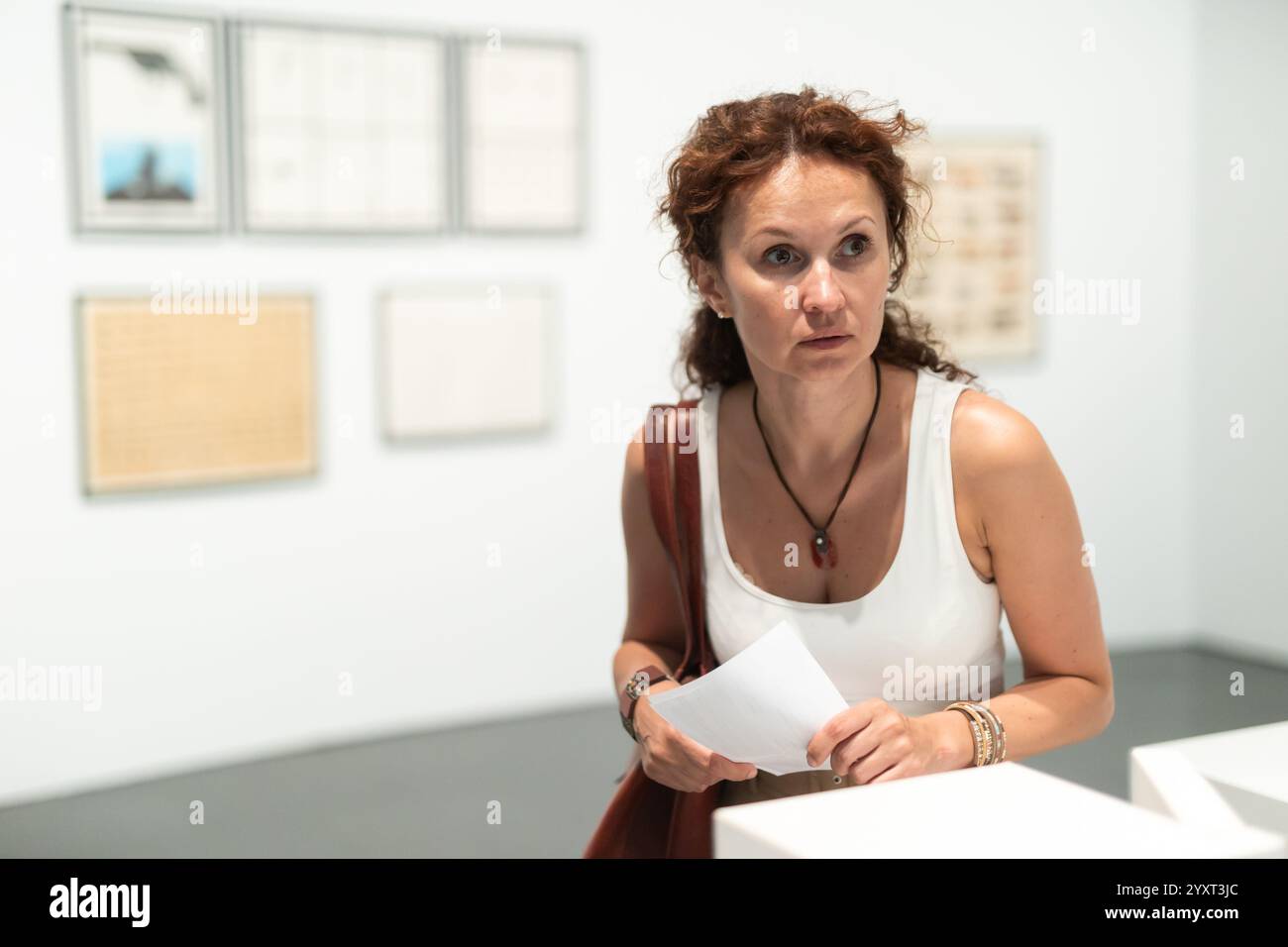 Woman observing photographs on display in photo gallery Stock Photo - Alamy