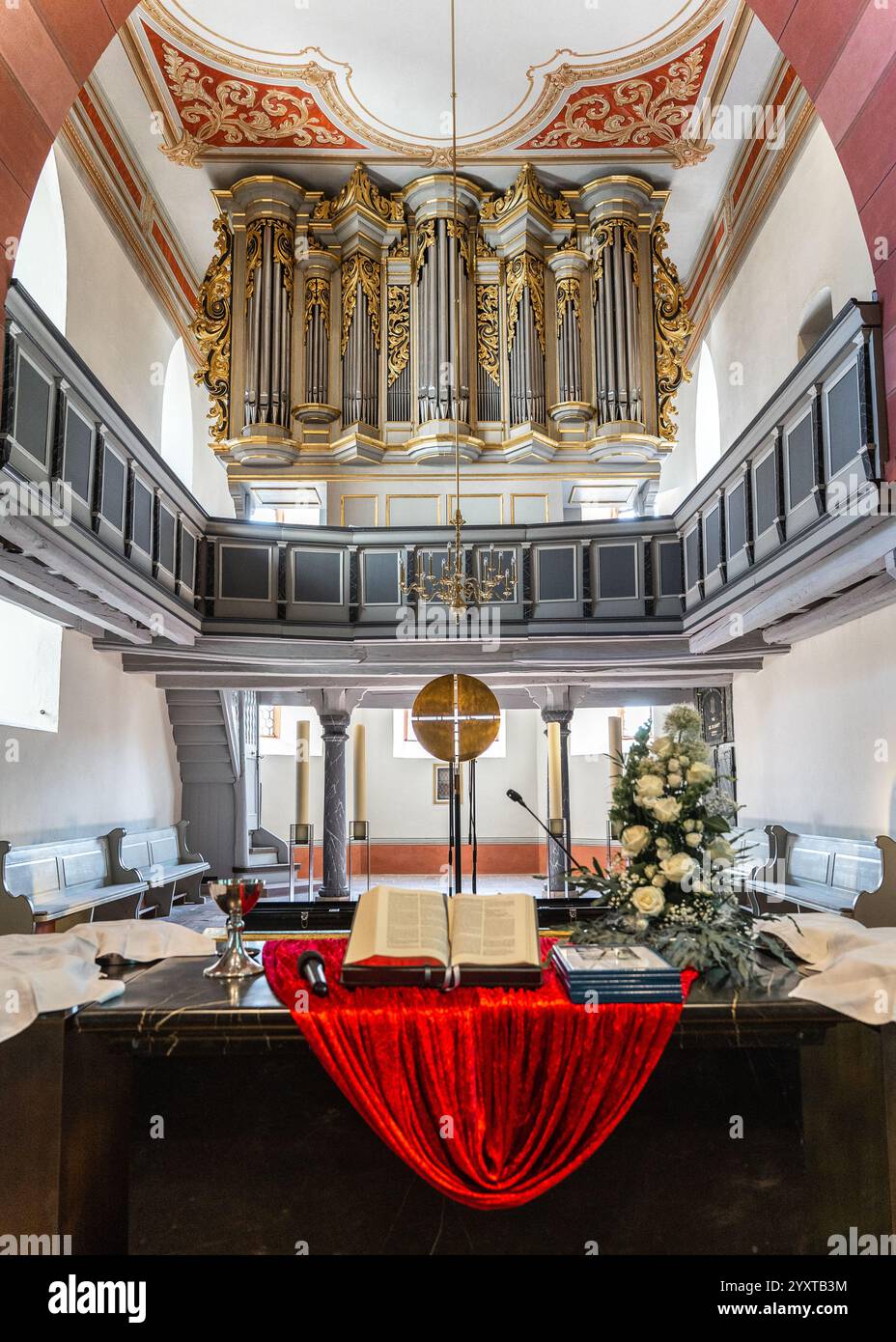 Catholic Church in Germany, altar with flowers, candles and an open ...