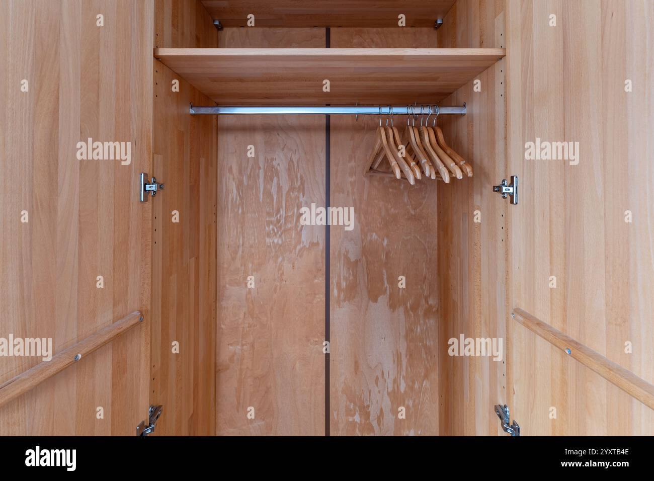 clothes hangers on rail in empty wardrobe Stock Photo - Alamy