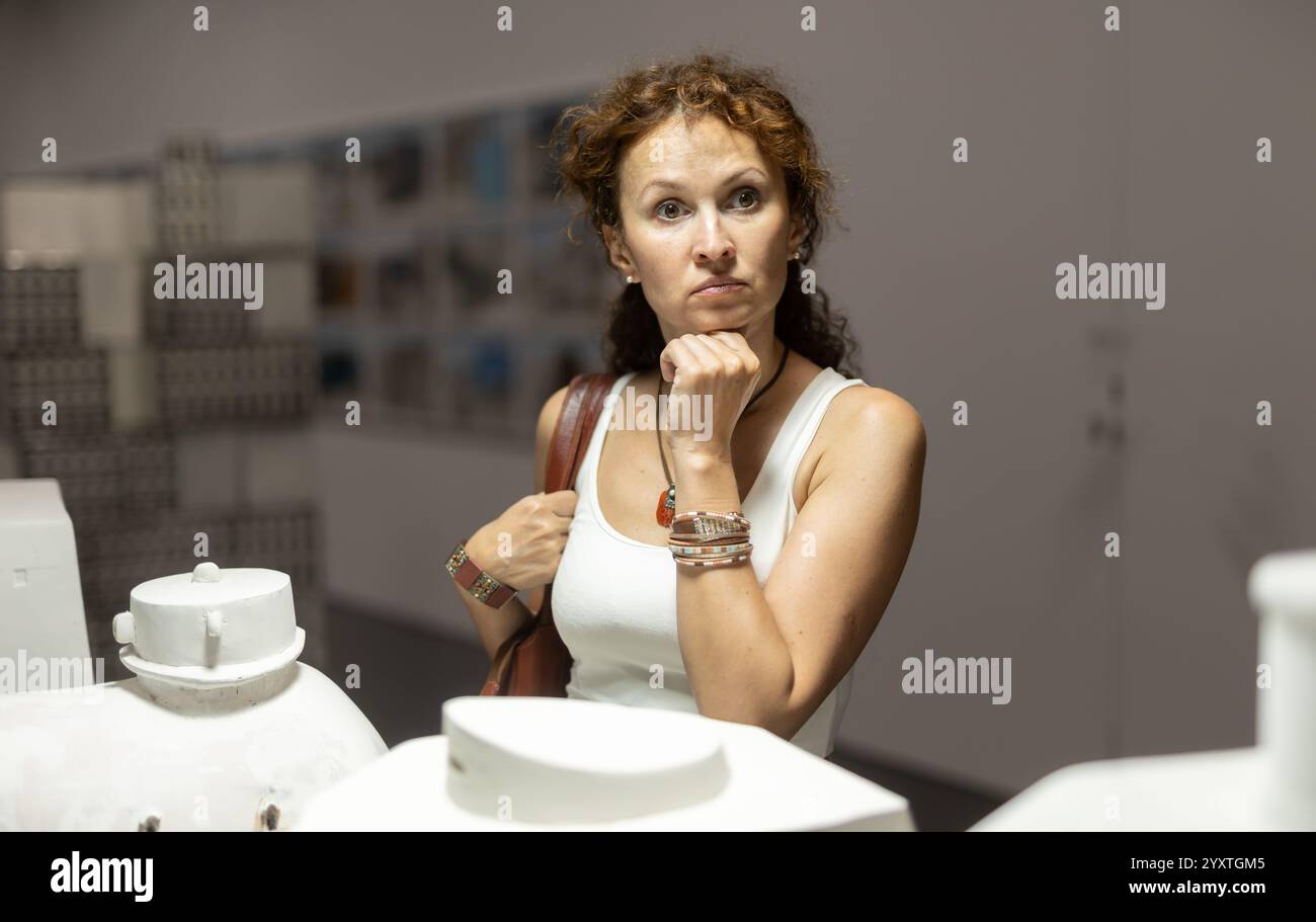 Middle-aged woman looking at building models in museum Stock Photo - Alamy