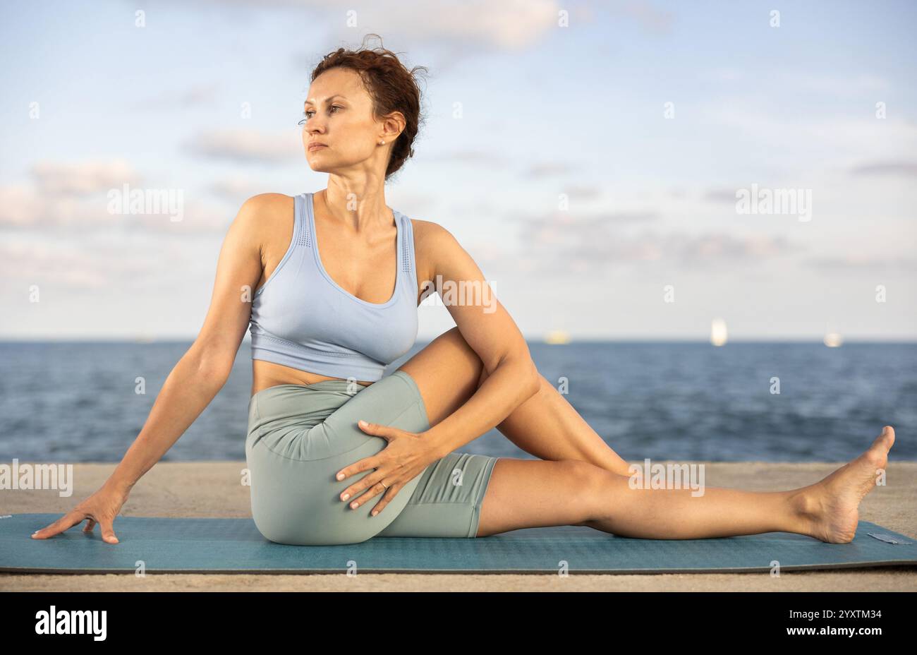 Woman performing Ardha Matsyendrasana position yoga training Stock ...