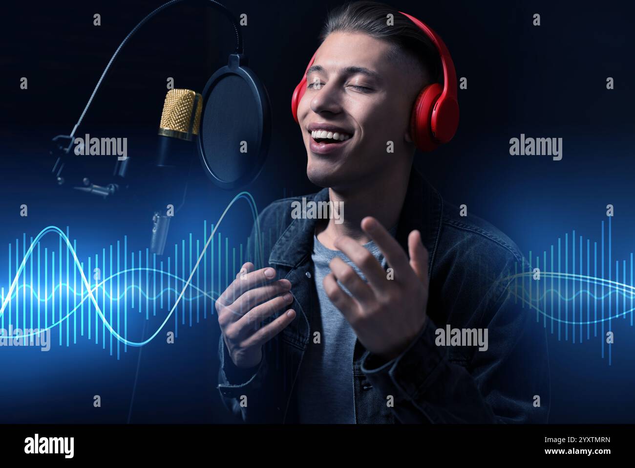 Man with headphones singing into microphone in professional record ...