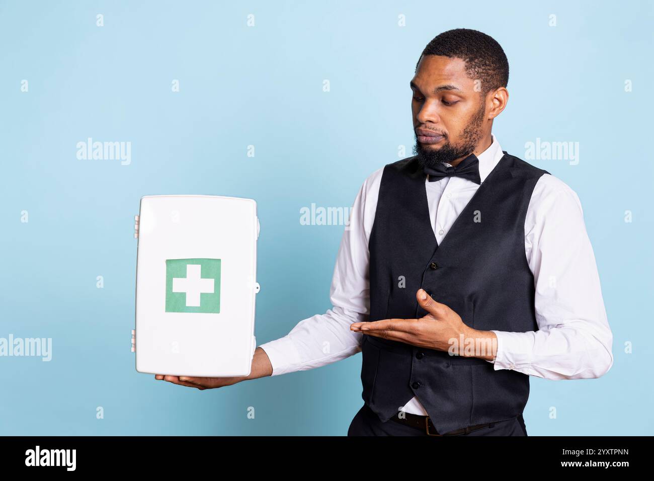 Hotel employee presenting a first aid kit used for medical emergencies ...